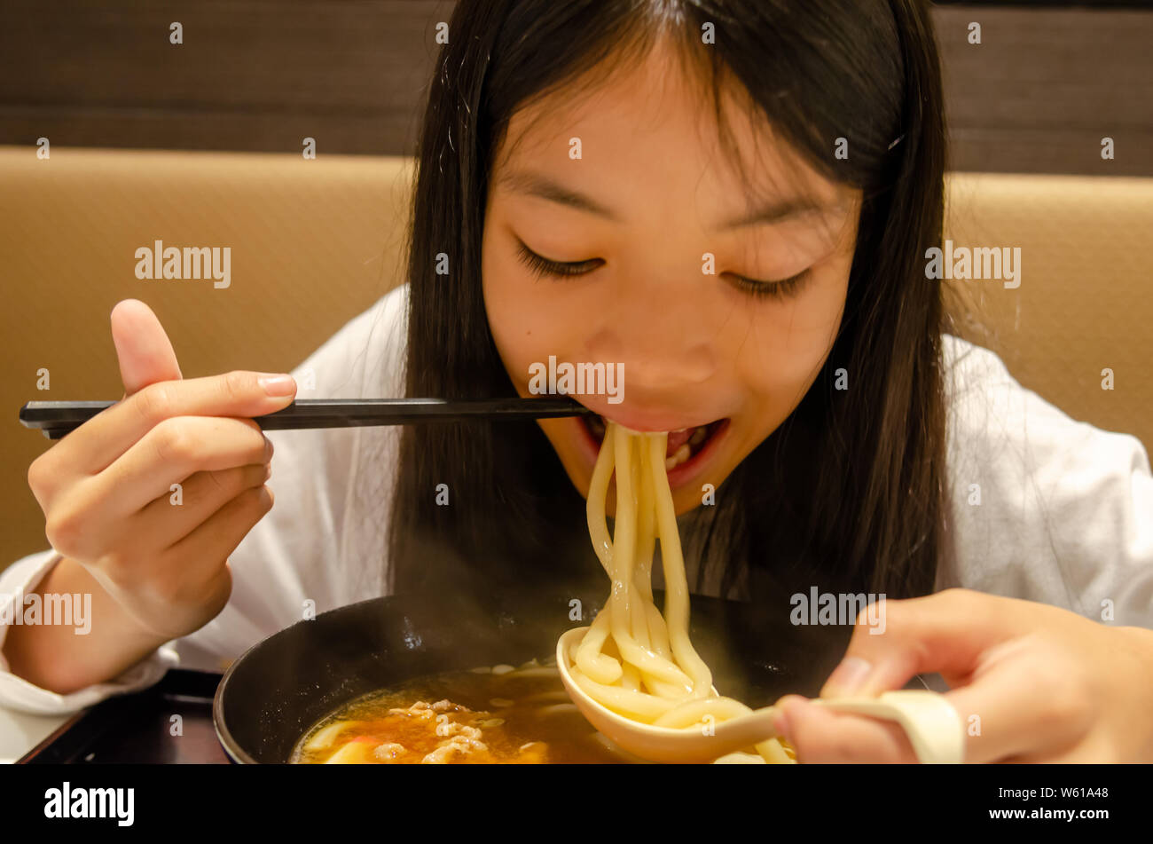 Asian girl eating ramen, Japanese food Stock Photo - Alamy