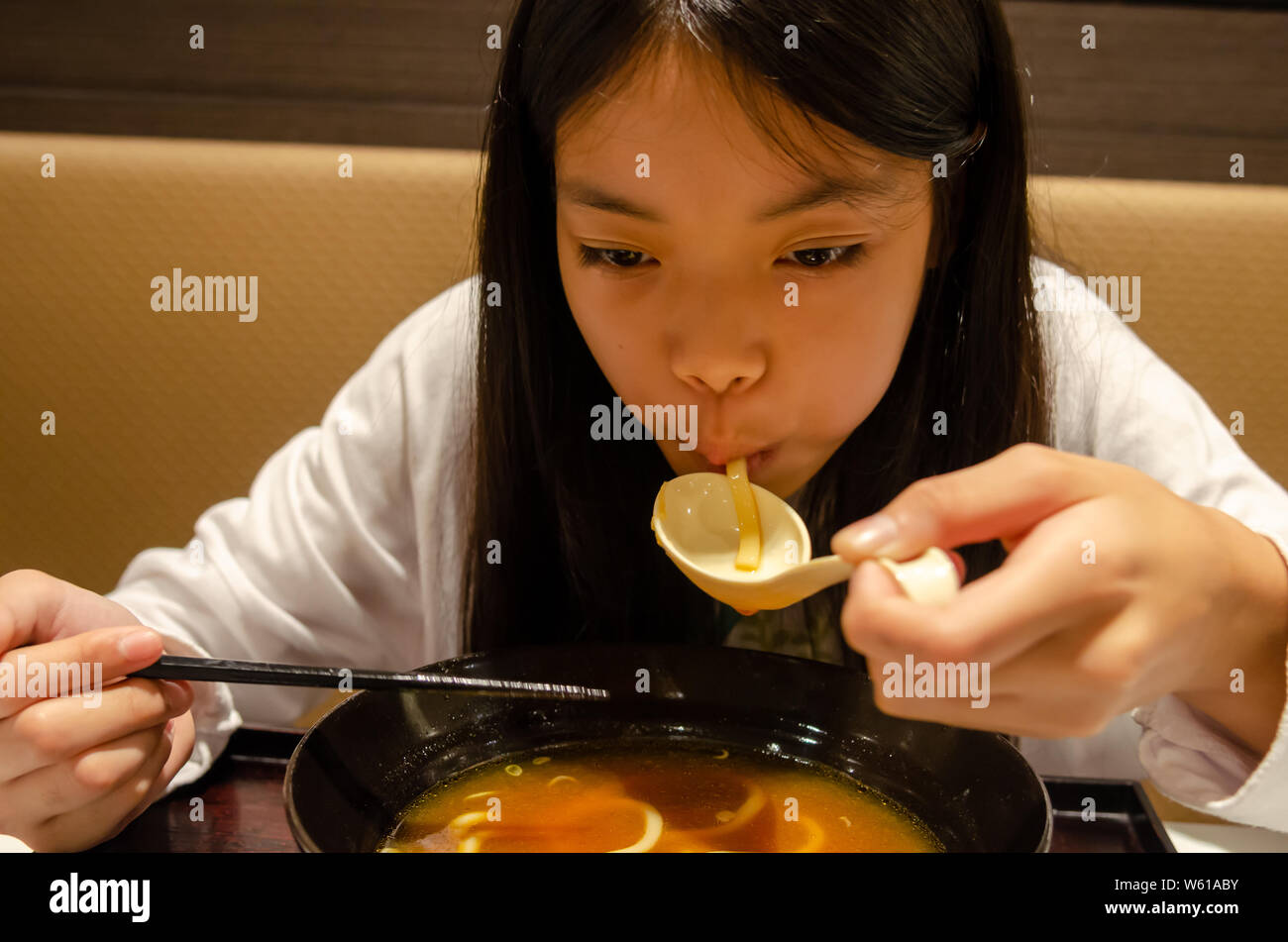 Asian girl eating ramen, Japanese food Stock Photo - Alamy