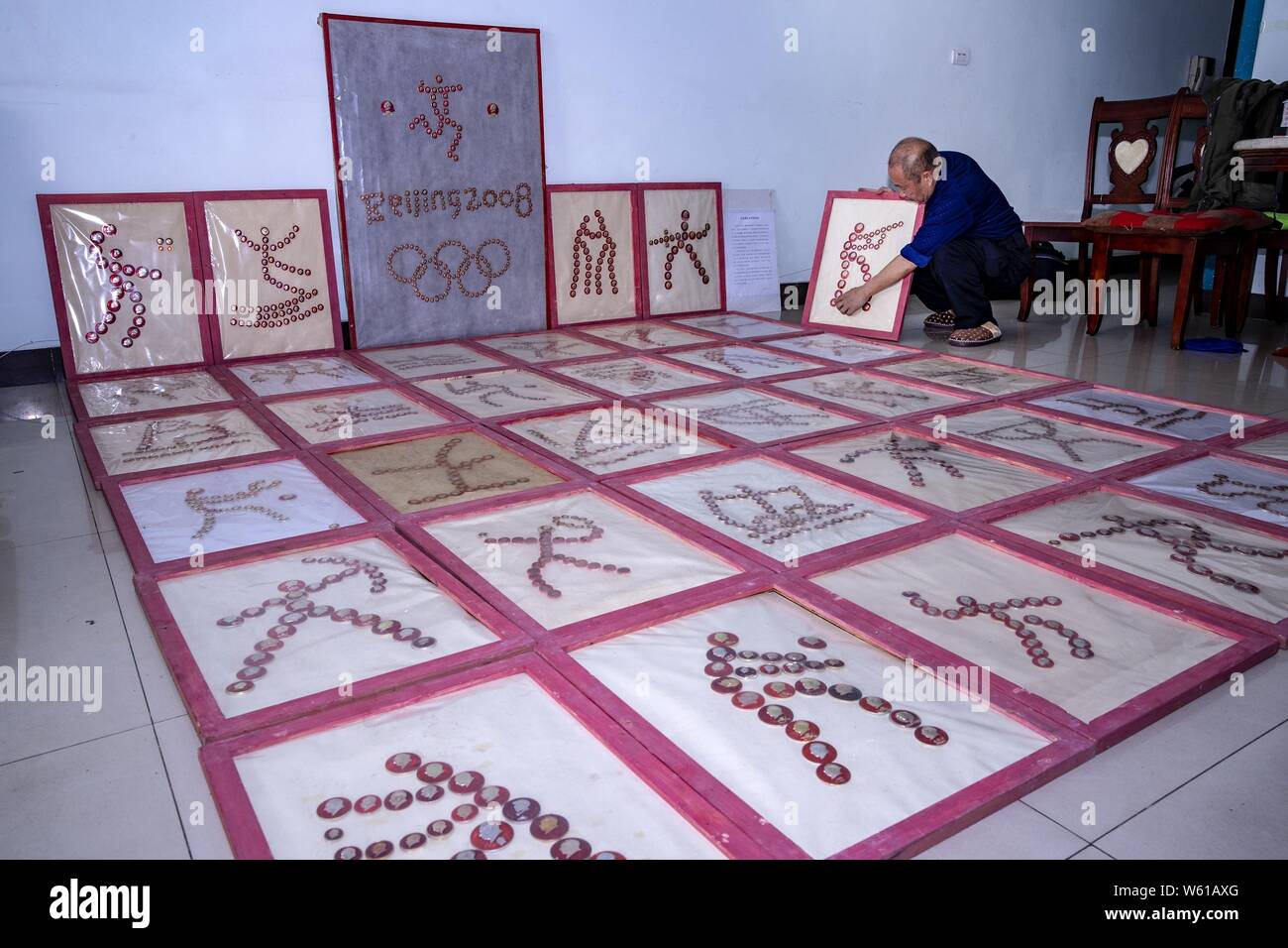 Chinese elderly man Huang Junde displays badges of the portrait of late ...