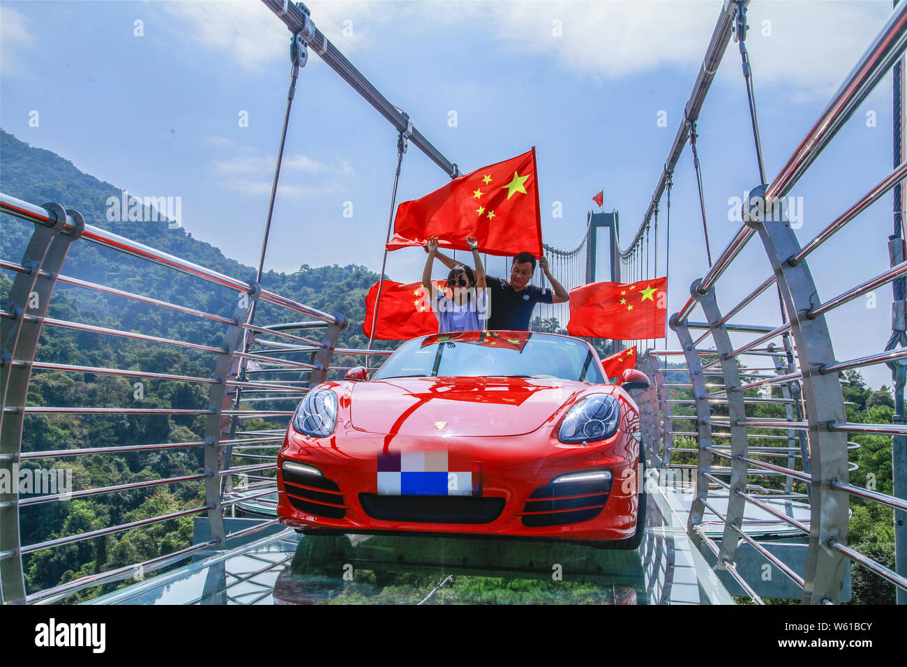 A Porsche sports car drives across Guangdong's longest glass-bottomed ...
