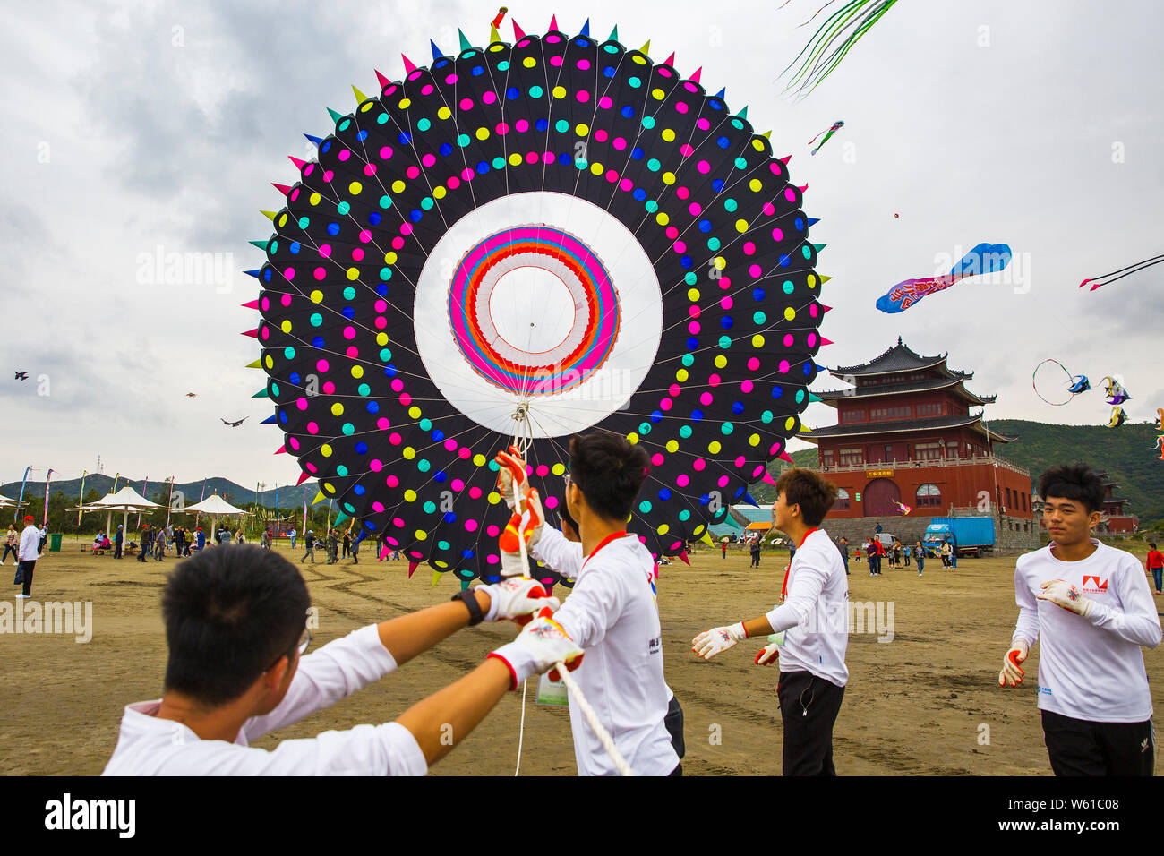 Competitors fly a big kite at a kite flying contest held at ...