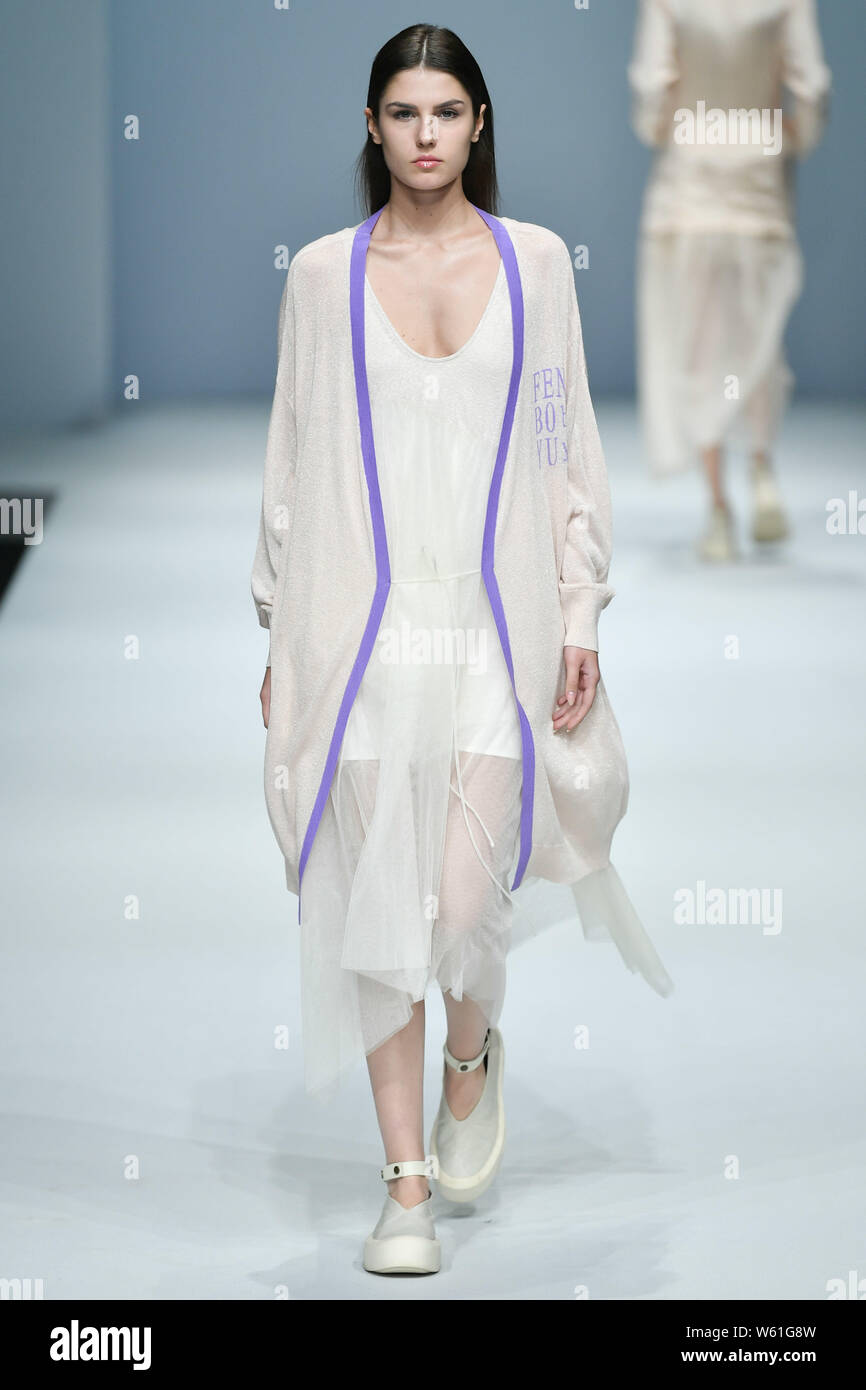 A model displays a new creation at the fashion show of SHANGSHOU & HELY ...