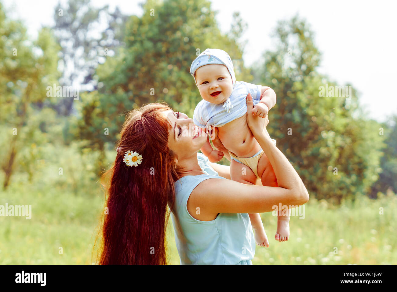 A young mother raised her baby in her arms Stock Photo - Alamy