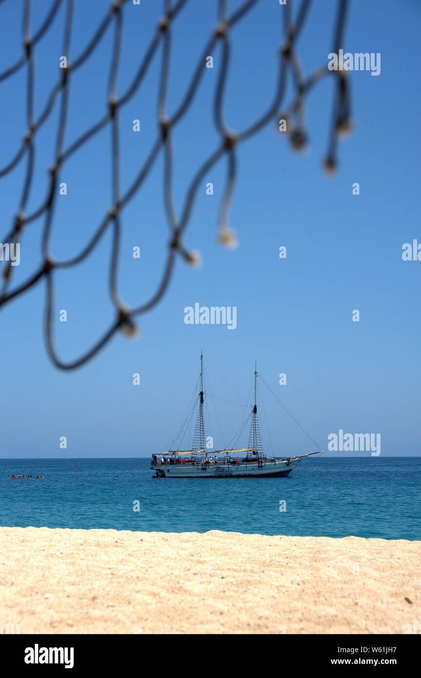 Sailboat at sea with view from a sandy beach Stock Photo - Alamy
