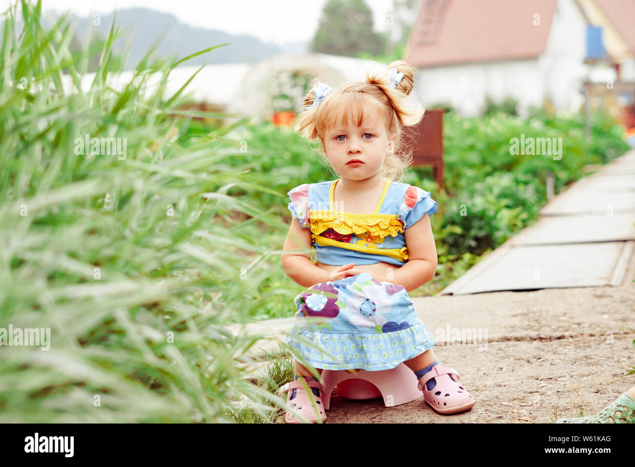 portrait of cute Happy little girl sitting on potty outdoors Stock ...