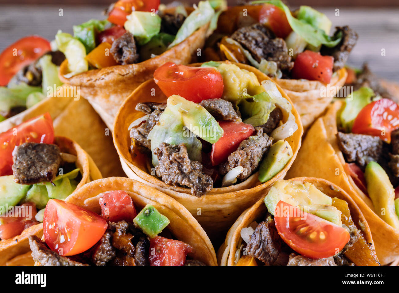 Beef salad in taco cones with pepper, tomato and avocado Stock Photo ...