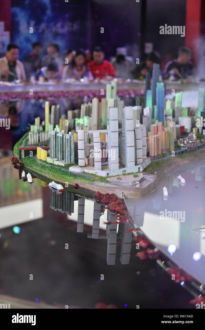 Chinese customers dine around a giant hotpot decorated with models of ...