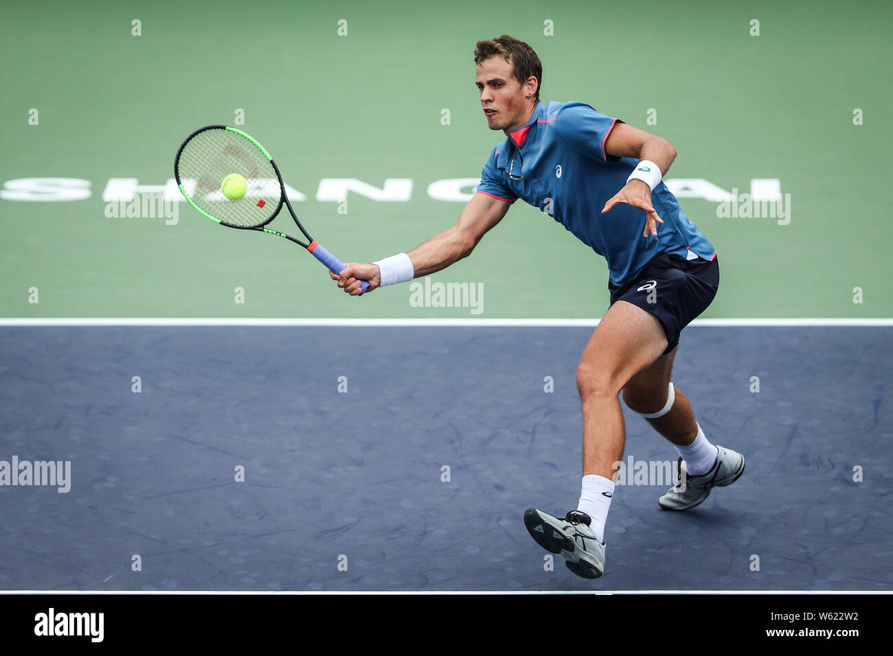 Vasek Pospisil of Canada returns a shot to Alex de Minaur of Australia ...