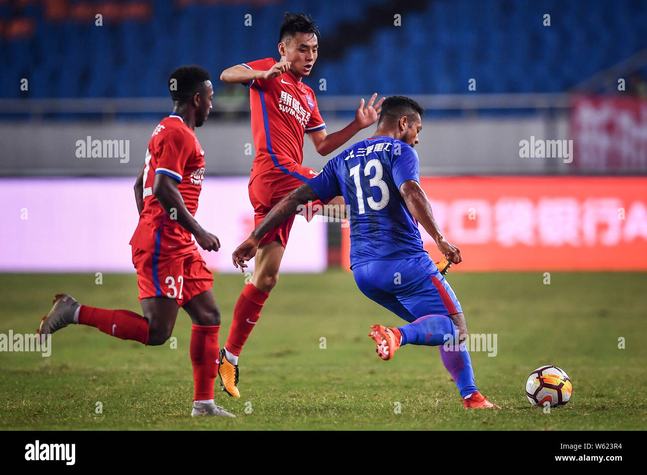 Brazilian football player Luiz Fernandinho, right, of Chongqing SWM kicks against Aidi ...