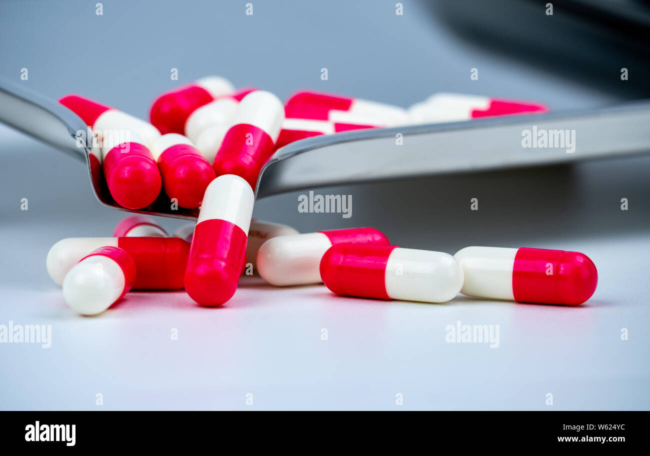 Red-white antibiotic capsule pills on stainless steel drug tray ...