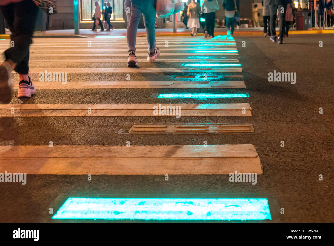 Pedestrians walk on China's first sidewalk-embedded pedestrian lights ...