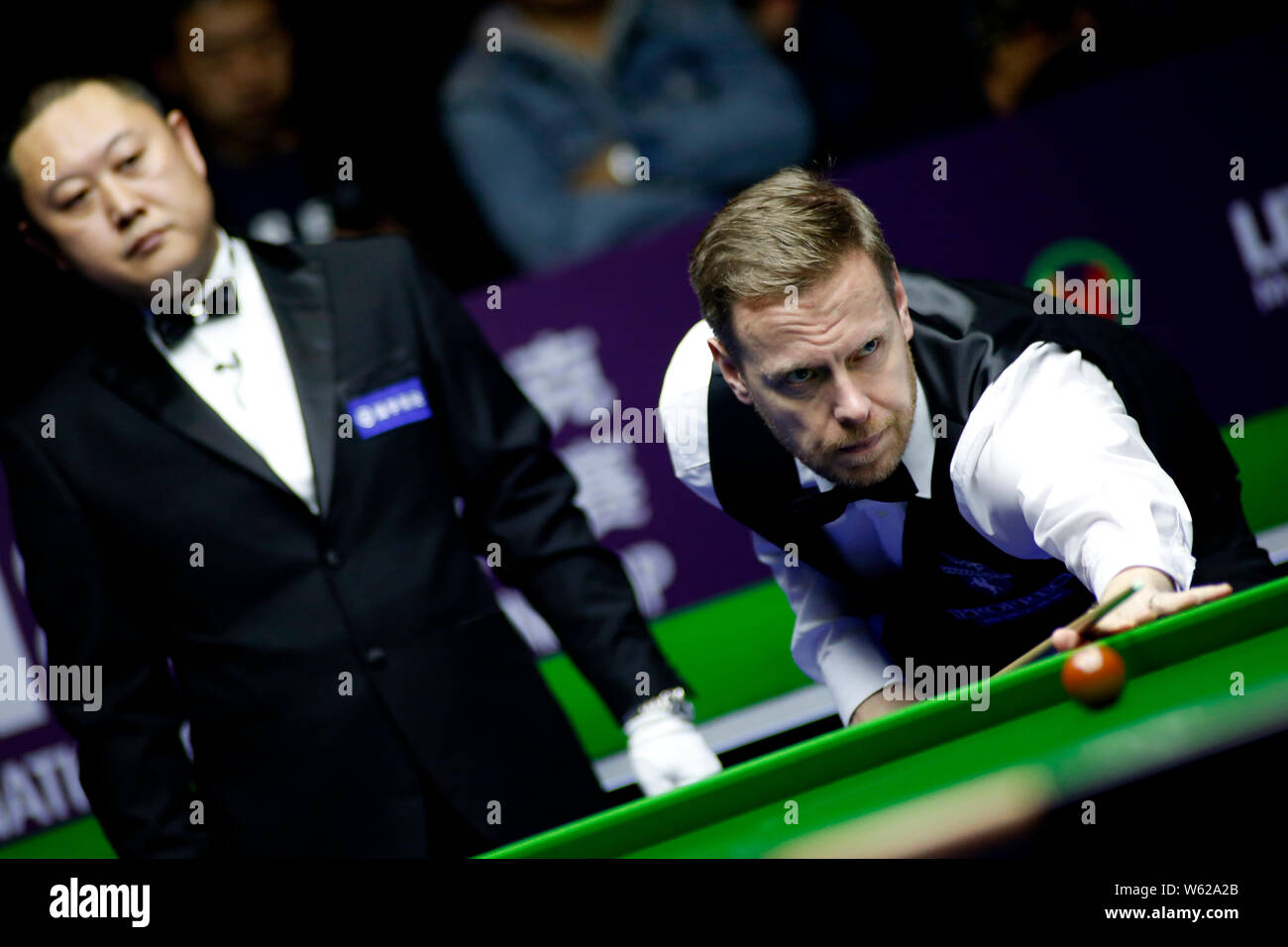 Robin Hull of Finland plays a shot to Ding Junhui of China in their ...