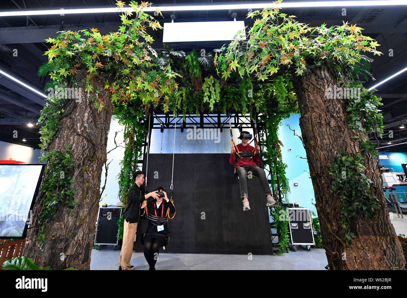 Visitors try out VR devices to experience bungee jumping at the SoReal ...