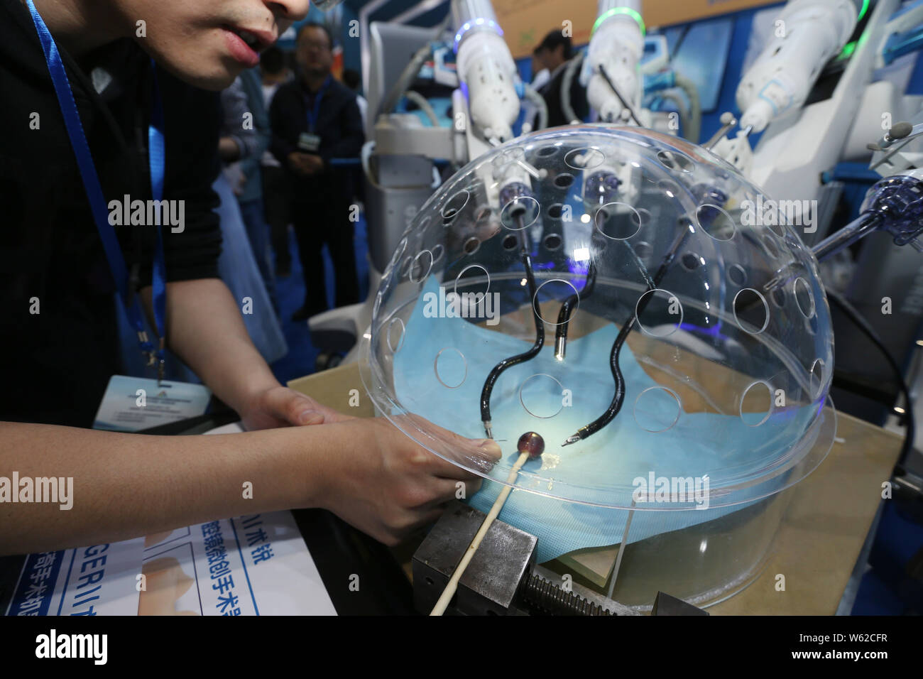 Members of the press look at a porotic laparoscopic surgery robot ...