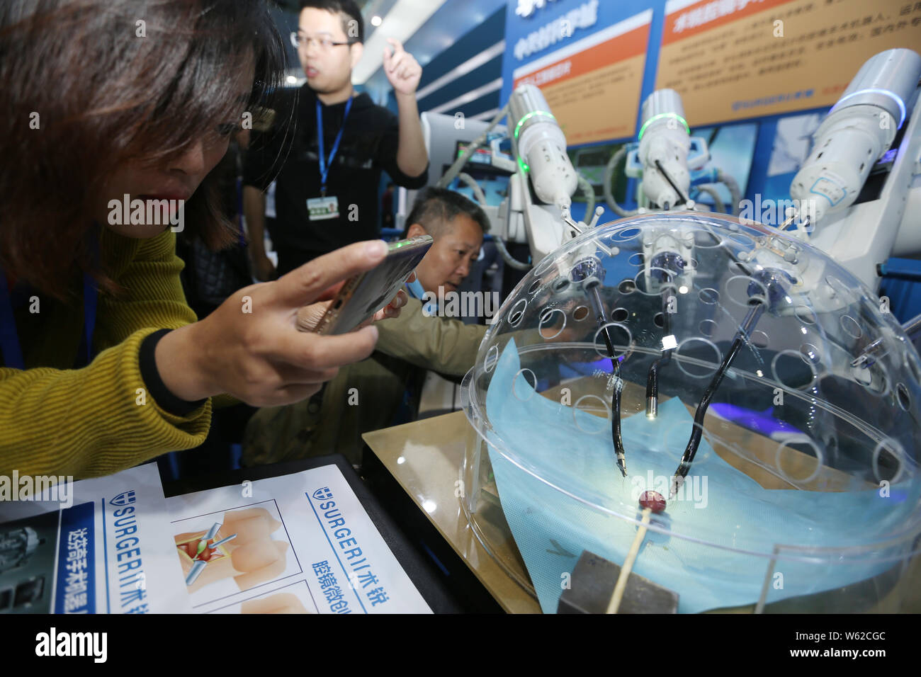 Members of the press look at a porotic laparoscopic surgery robot ...