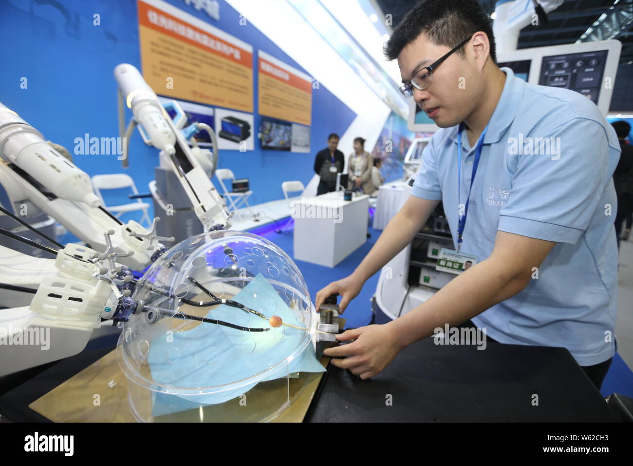 Members of the press look at a porotic laparoscopic surgery robot ...