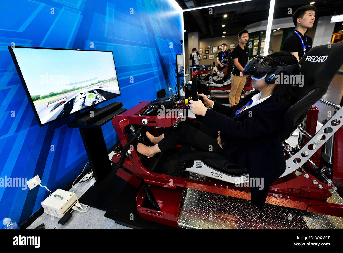A visitor tries out a VR device to drive a racing car at the SoReal VR ...
