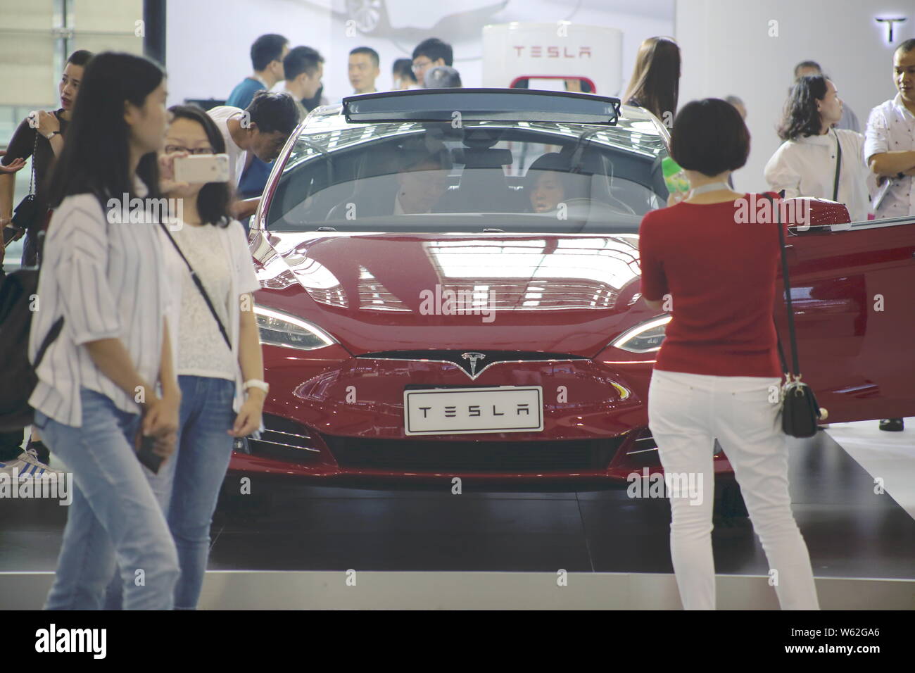 --FILE--People look at a Tesla model S electric car on display during ...