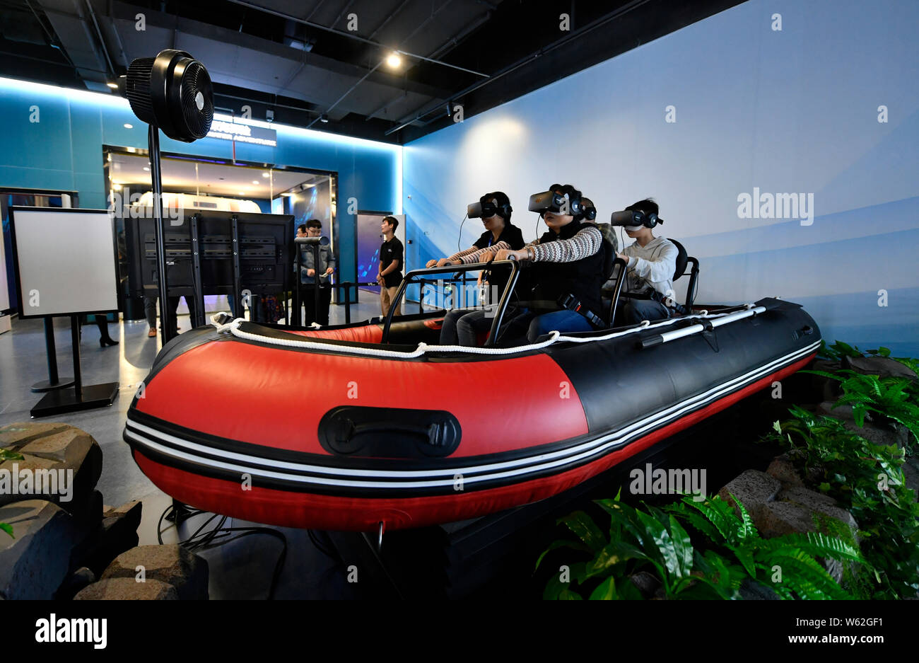 Visitors try out VR devices to ride a hovercraft at the SoReal VR amusement park, which is the ...