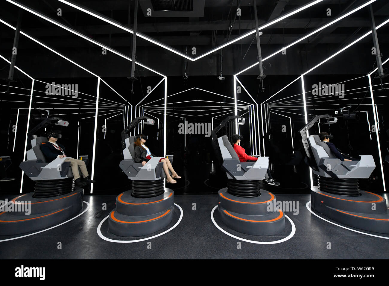 Visitors try out VR devices to watch movies at the SoReal VR amusement ...