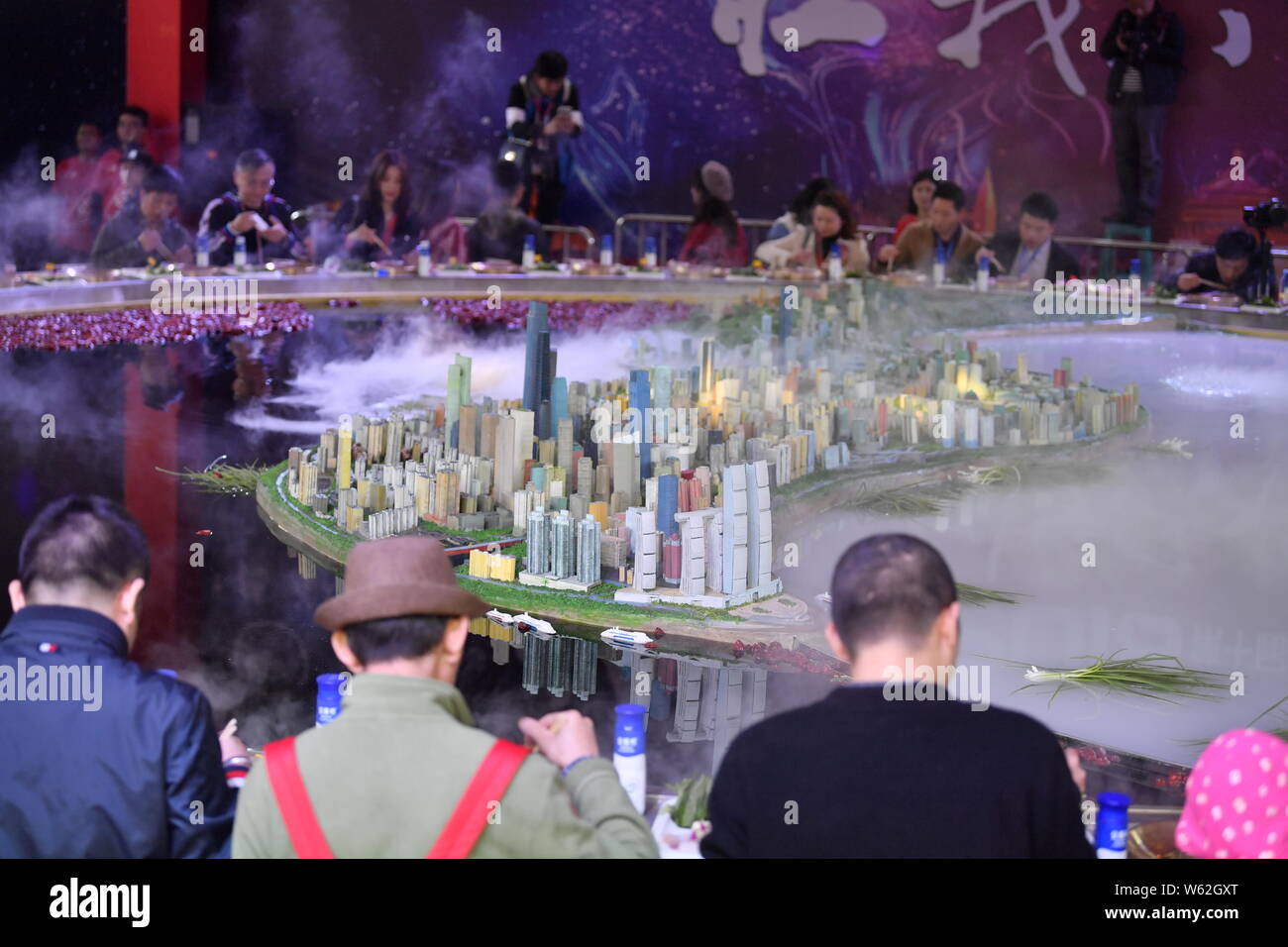 Chinese customers dine around a giant hotpot decorated with models of ...