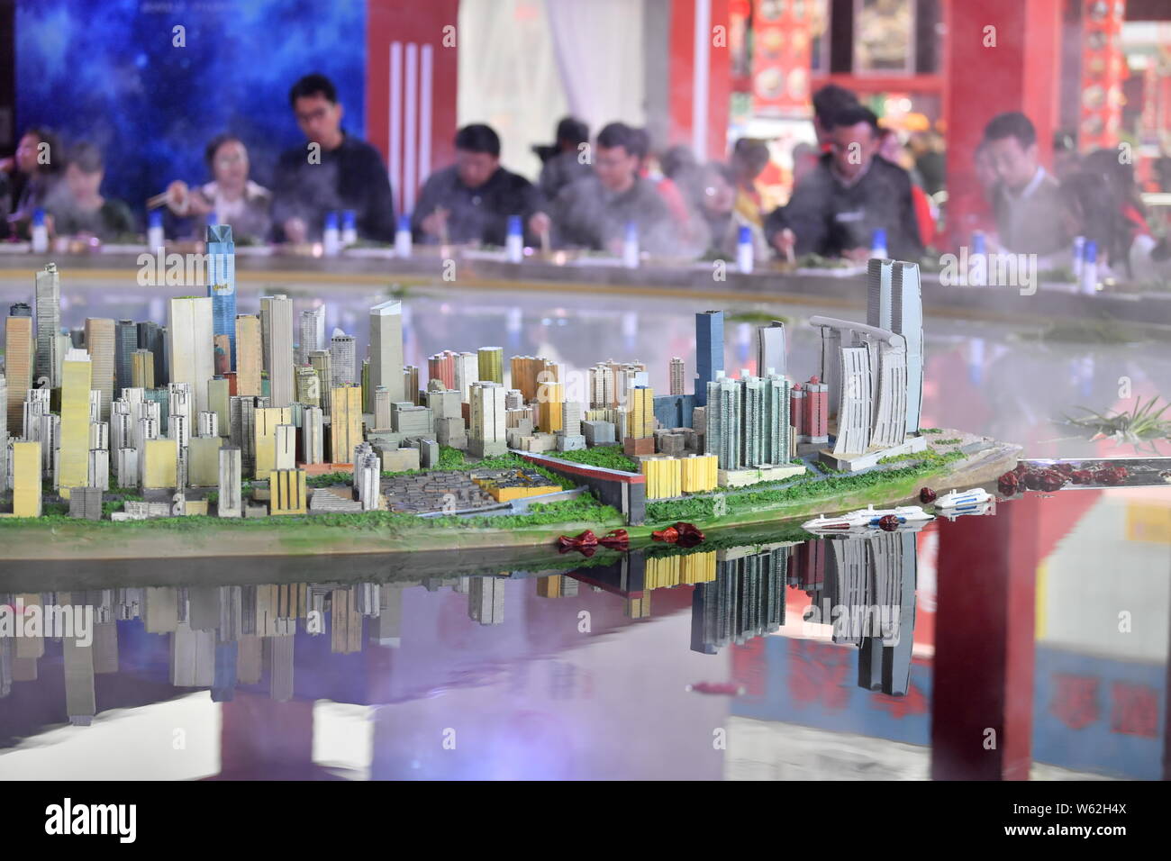 Chinese customers dine around a giant hotpot decorated with models of ...