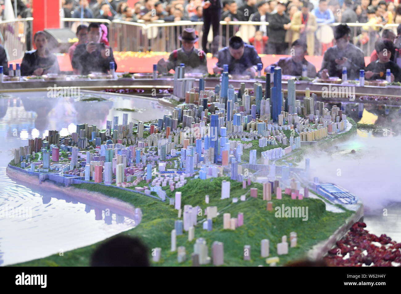 Chinese customers dine around a giant hotpot decorated with models of ...