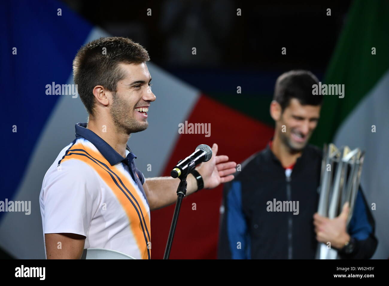 Borna Coric of Croatia speaks after being defeated by Novak Djokovic of ...