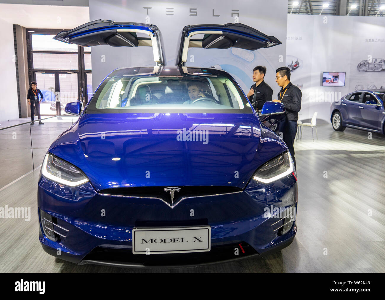 --FILE--People look at a Tesla Model X electric car on display during ...