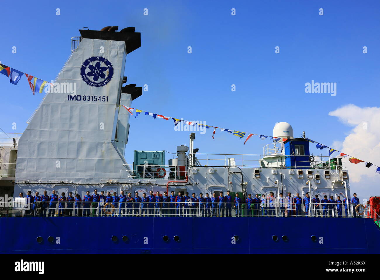 Scientists wave after the oceanic research vessel Tansuo-1, which ...