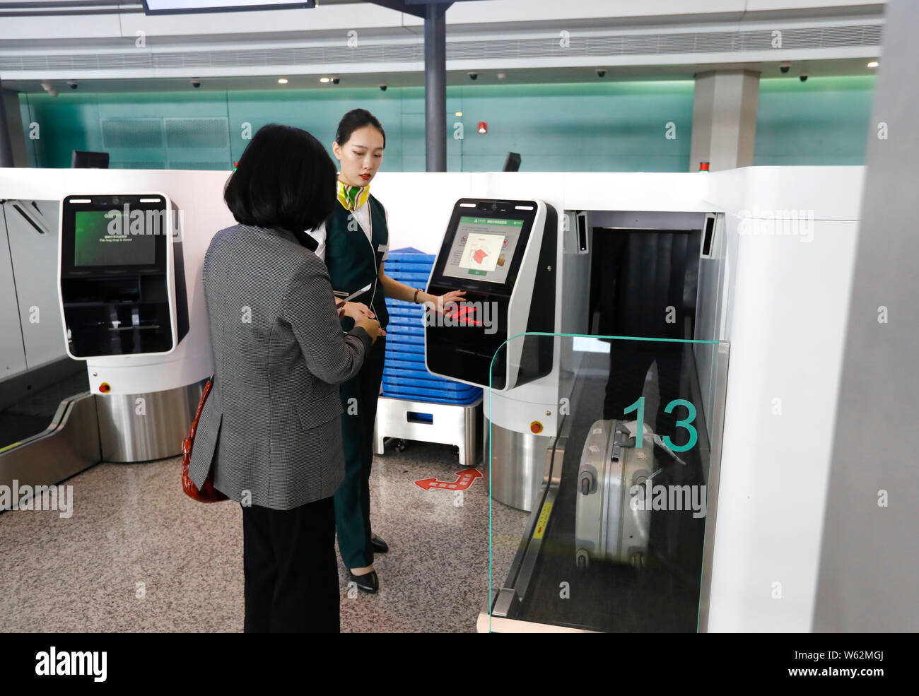 A passenger uses a self-service machine at the T1 terminal of Shanghai ...