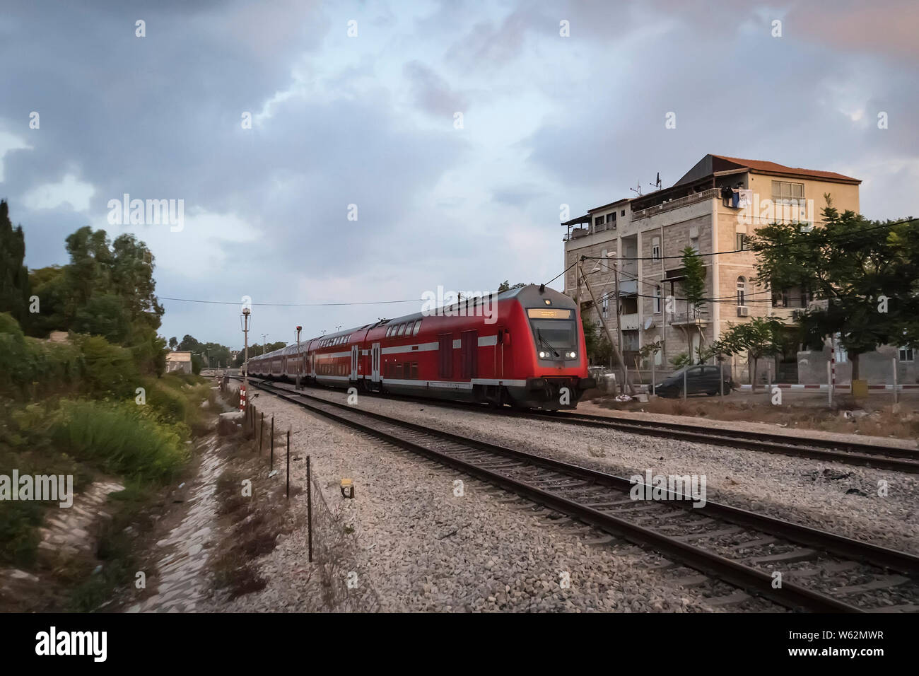 Modern high speed train on a cloudy day moving in suburbs. Railway ...