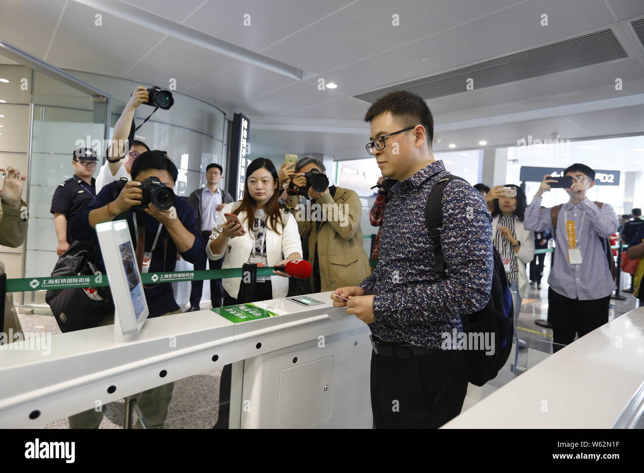 A passenger scans his boarding pass on a self-service boarding machine ...