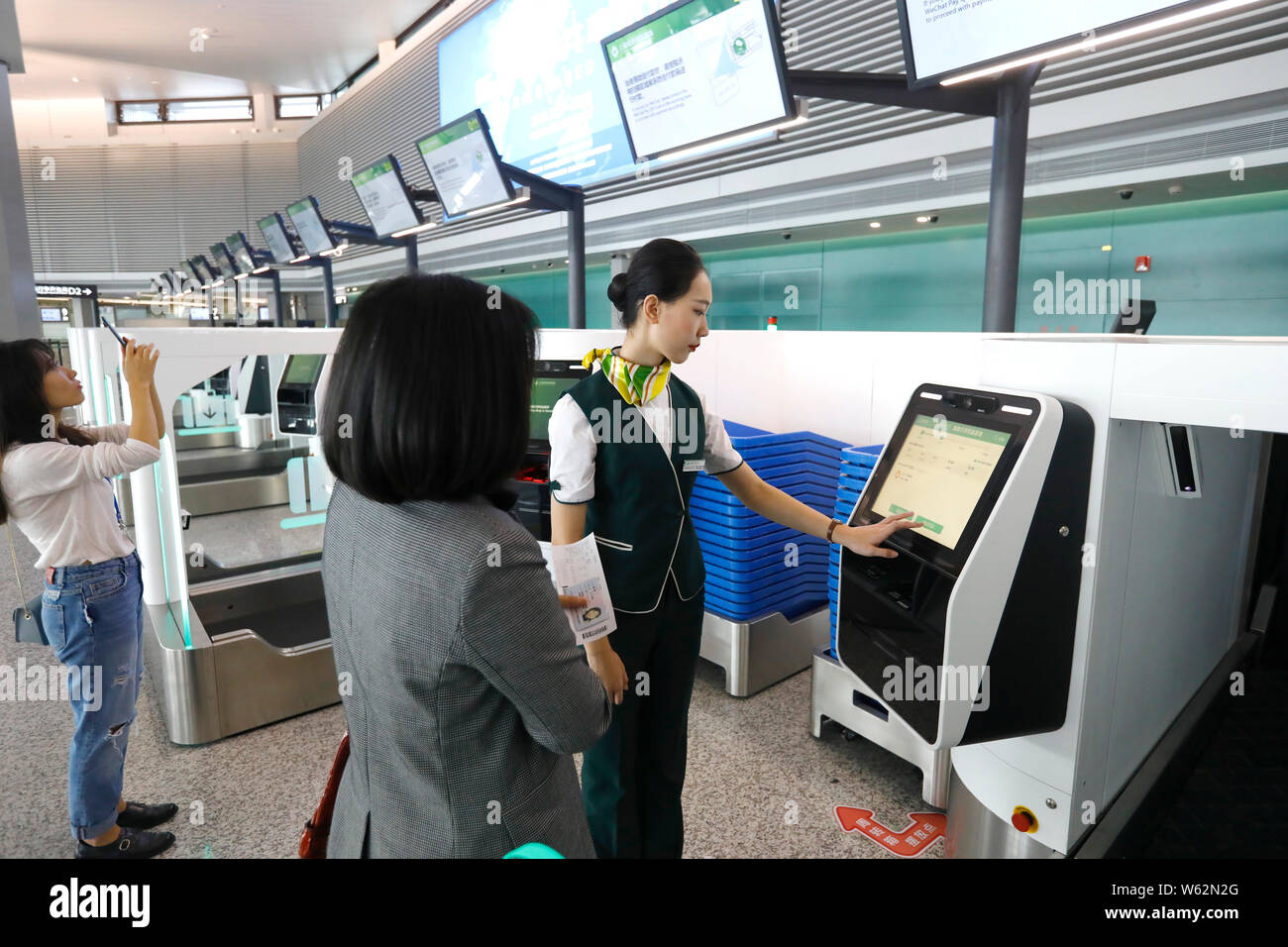 A passenger uses a self-service machine at the T1 terminal of Shanghai ...