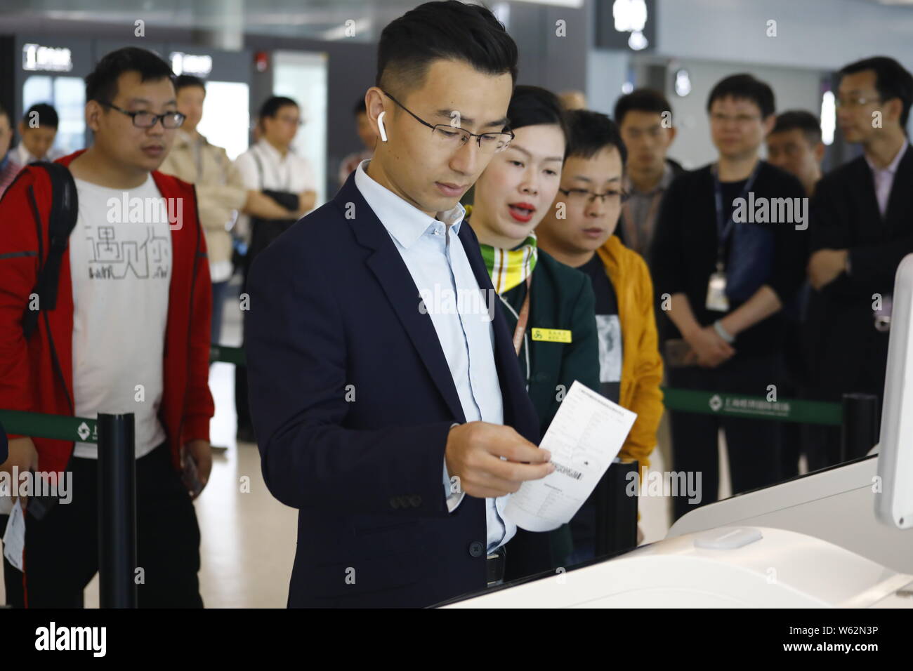 A passenger scans his boarding pass on a self-service boarding machine ...