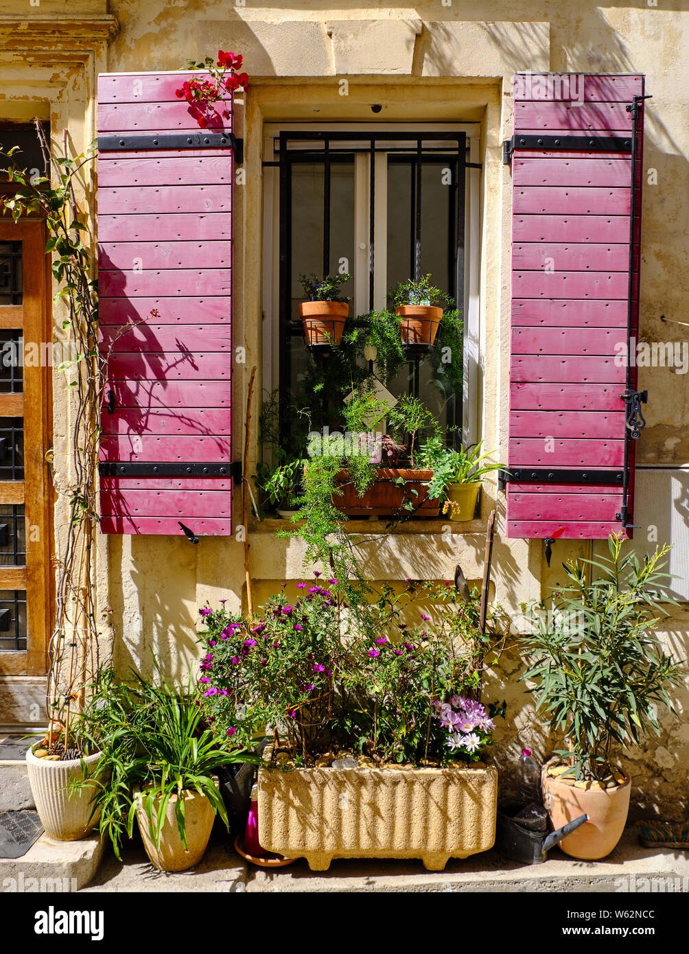 Typical Provence window with red shutters, overloaded with flower pots ...
