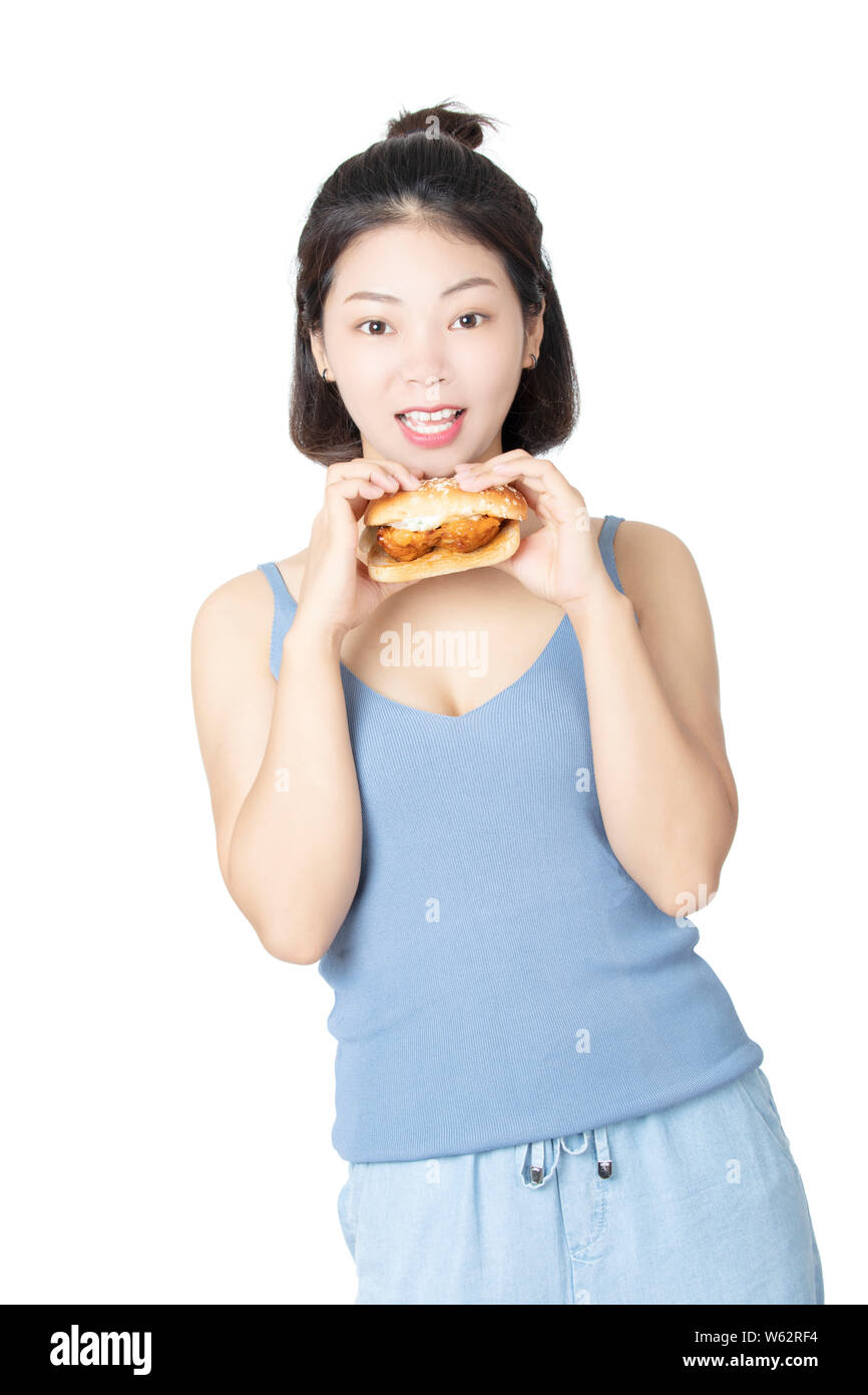 Beautiful Chinese American woman eating a Chicken Sandwich isolated on ...