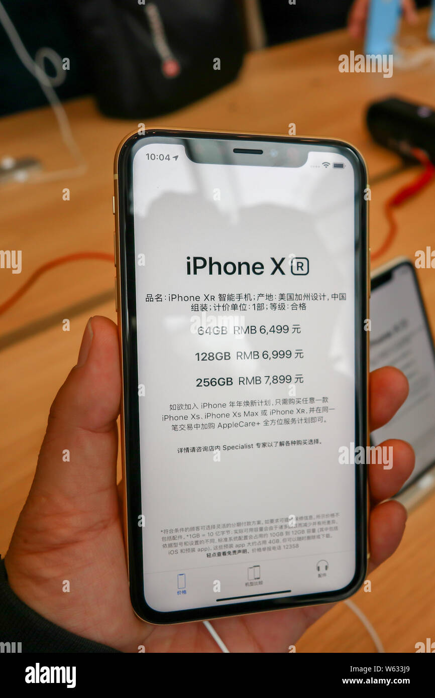 A Chinese customer tries out an iPhone XR smartphone at the Apple Store ...