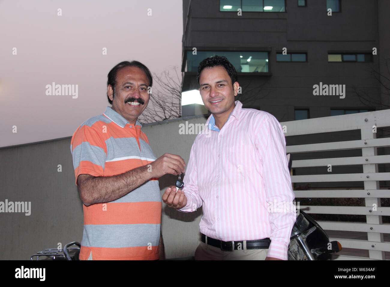Man giving bike key to his son Stock Photo - Alamy