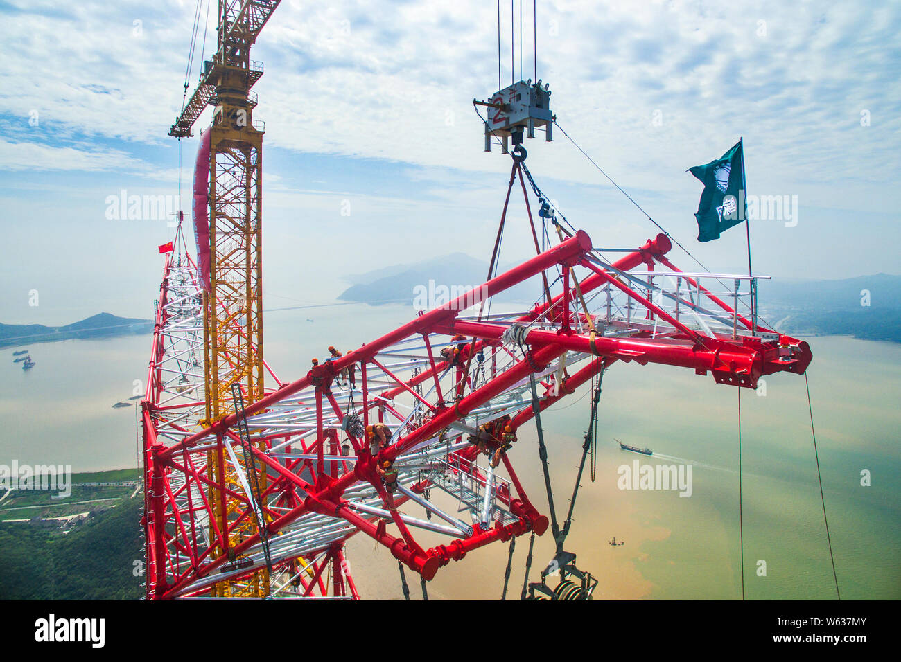 Workers labor at the world's tallest transmission towers that support the 2,656-meter-long power ...