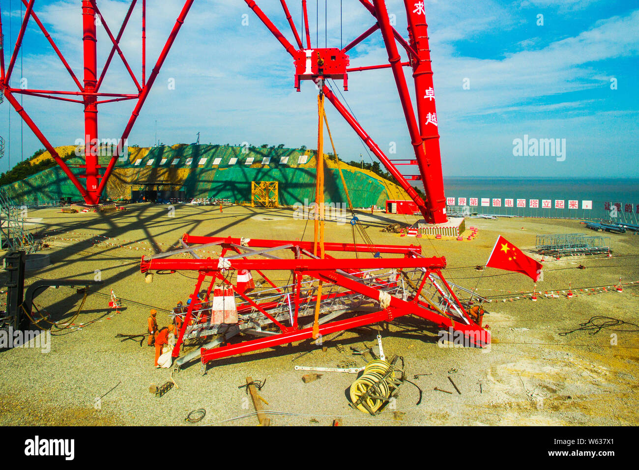Workers labor at the world's tallest transmission towers that support the 2,656-meter-long power ...