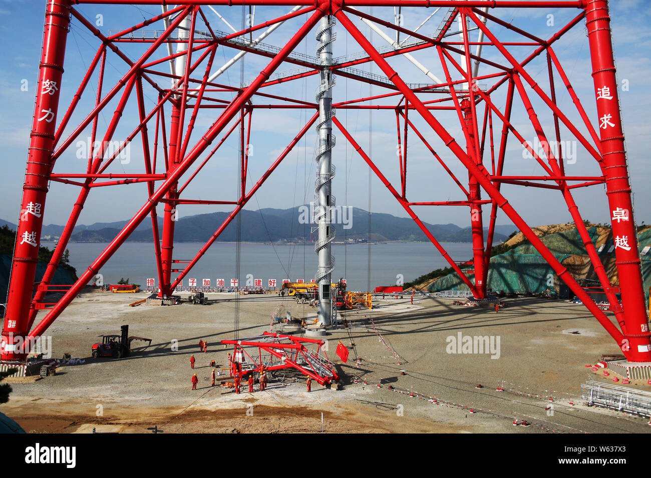 Workers labor at the world's tallest transmission towers that support the 2,656-meter-long power ...