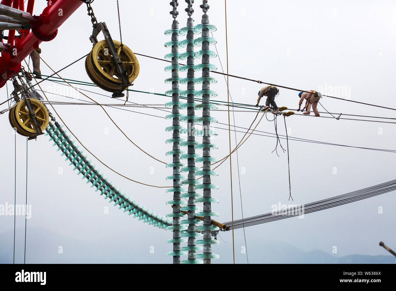 Chinese workers check on the Zhoushan 500 KV networking power transmission project across ...