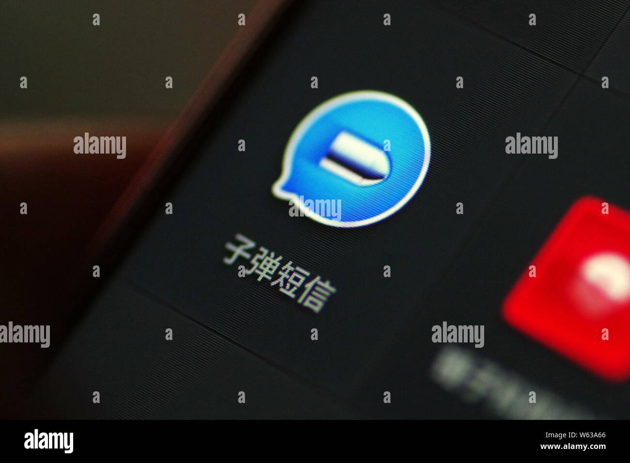 A Chinese mobile phone user looks at the icon of the messaging app ...