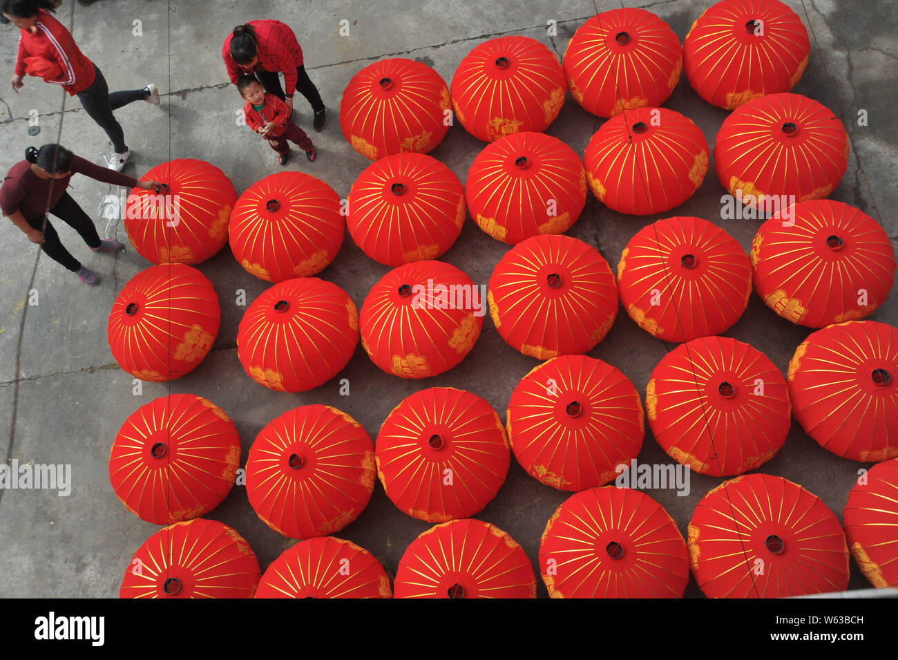 Chinese workers make red lanterns for the upcoming National Day at a ...