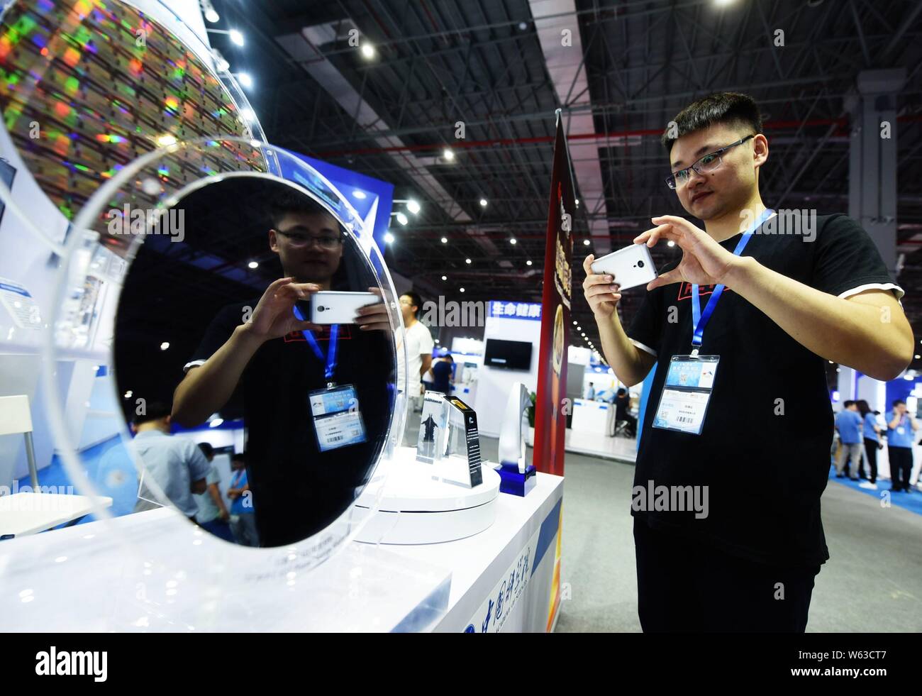 A Chinese visitor takes photos of China's self-developed 40nm 12-inch ...