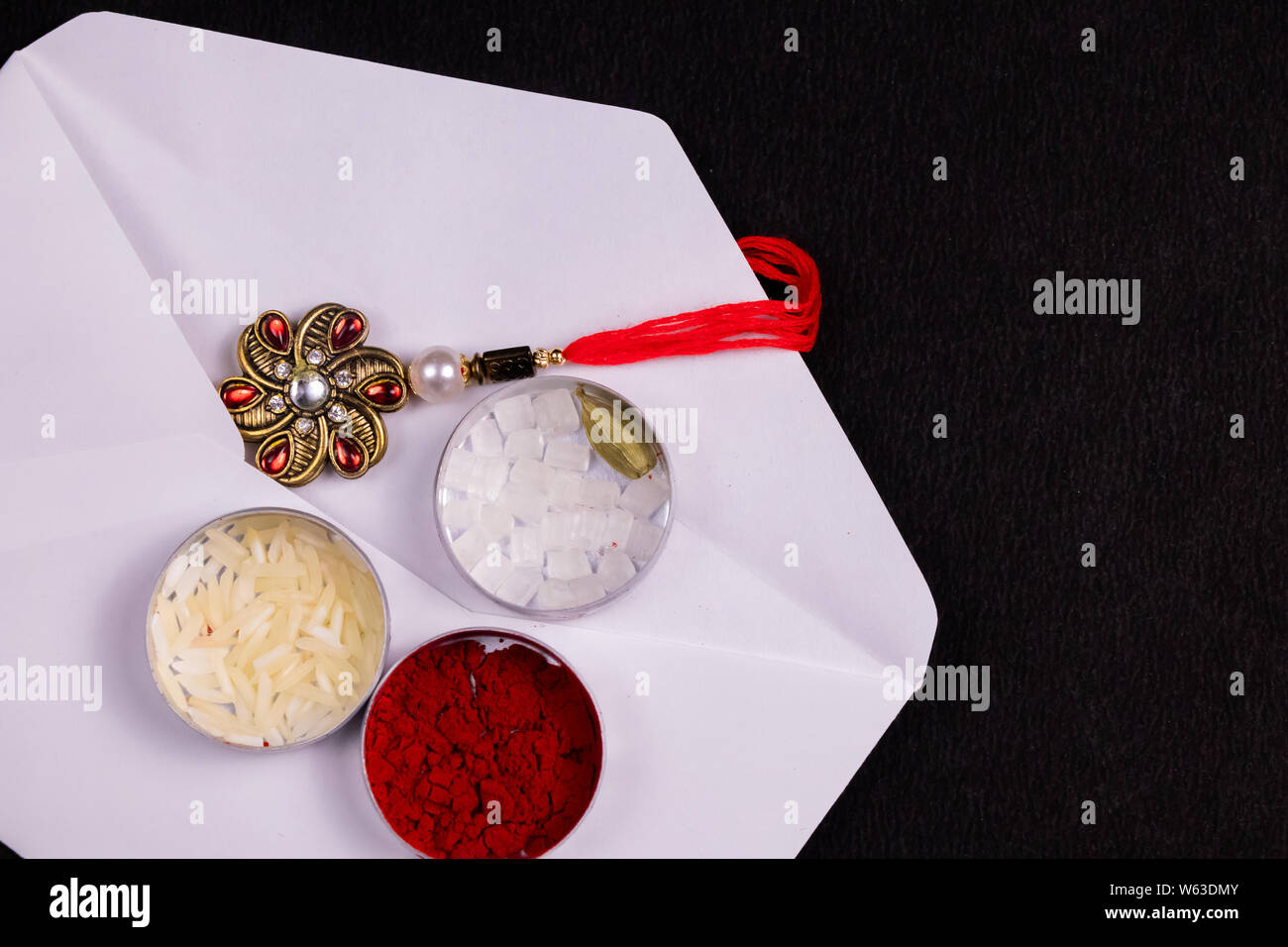 Indian Festival concept - Elegant Rakhi in a white envelope with rice ...