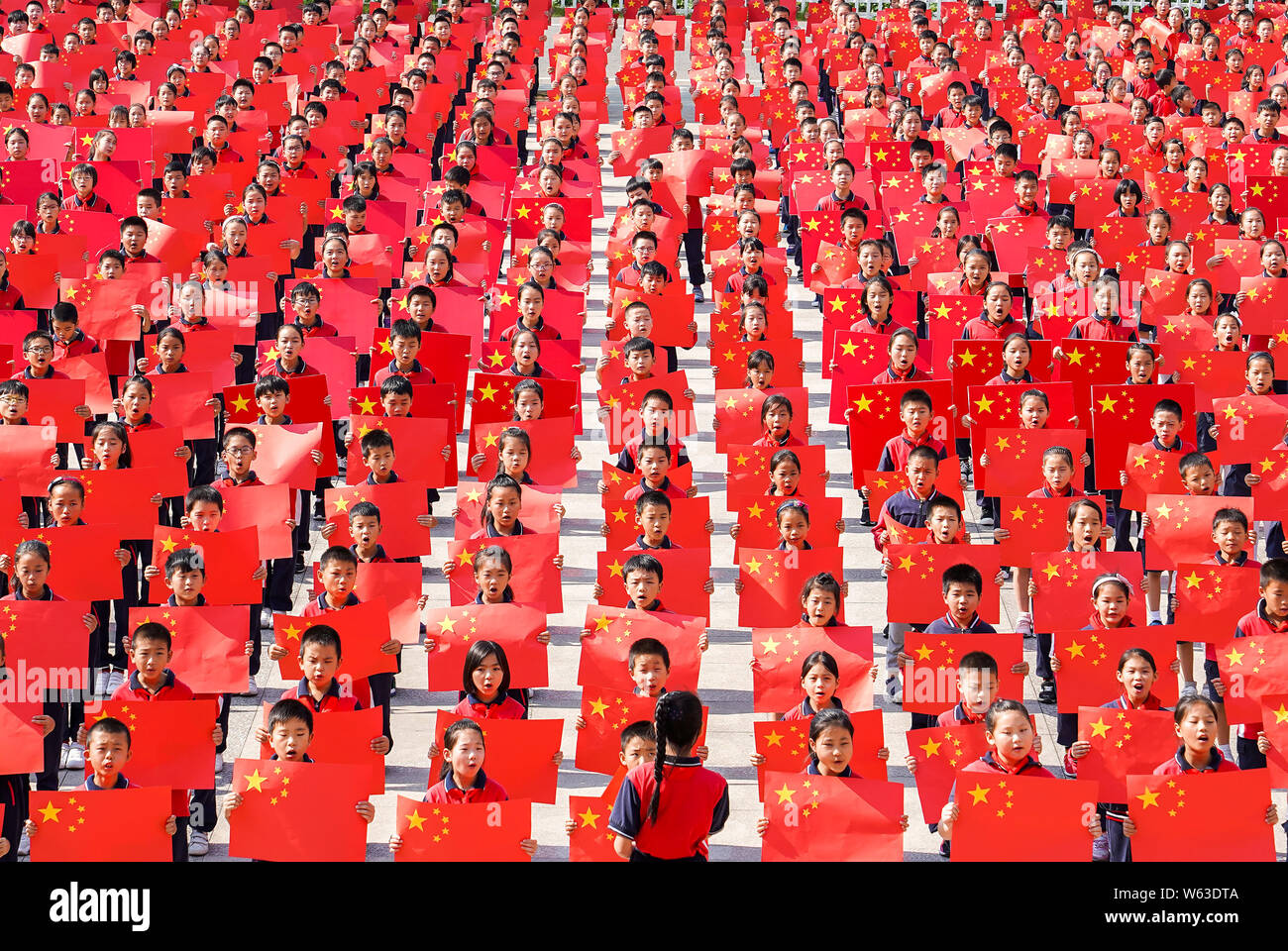 Young Chinese students hold up national flags they made by themselves ...