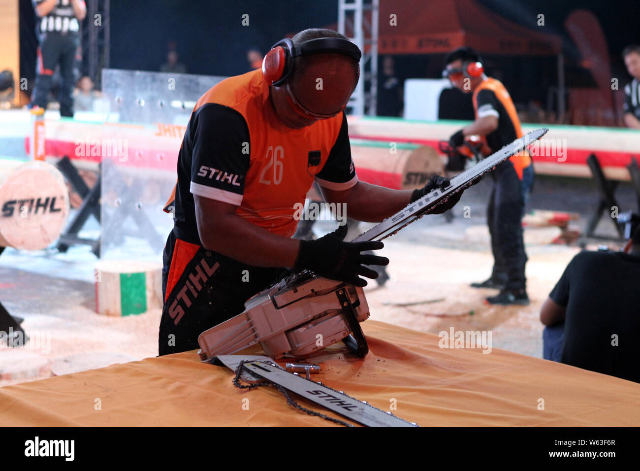 A Chinese contestant changes the saw blade of his chainsaw during the ...