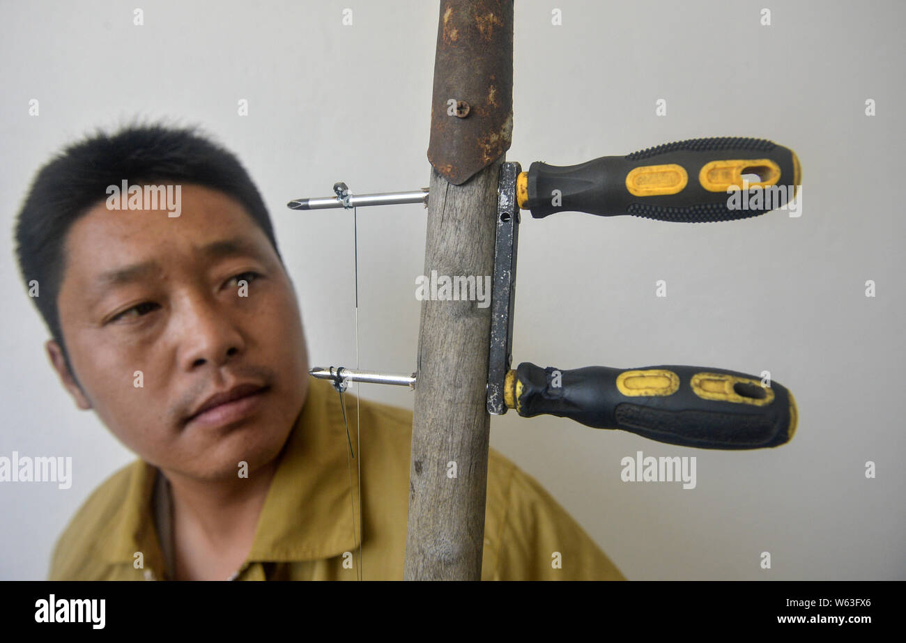 Chinese farmer Zhu Yue plays a self-made Chinese bowed musical ...